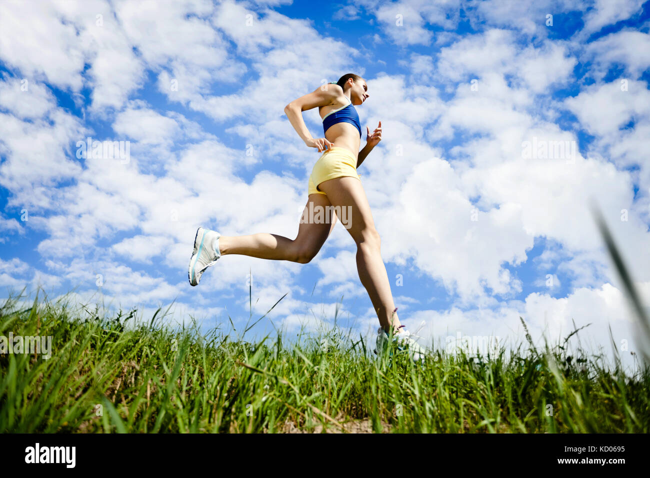 Young woman running outdoor over blue sky Stock Photo - Alamy