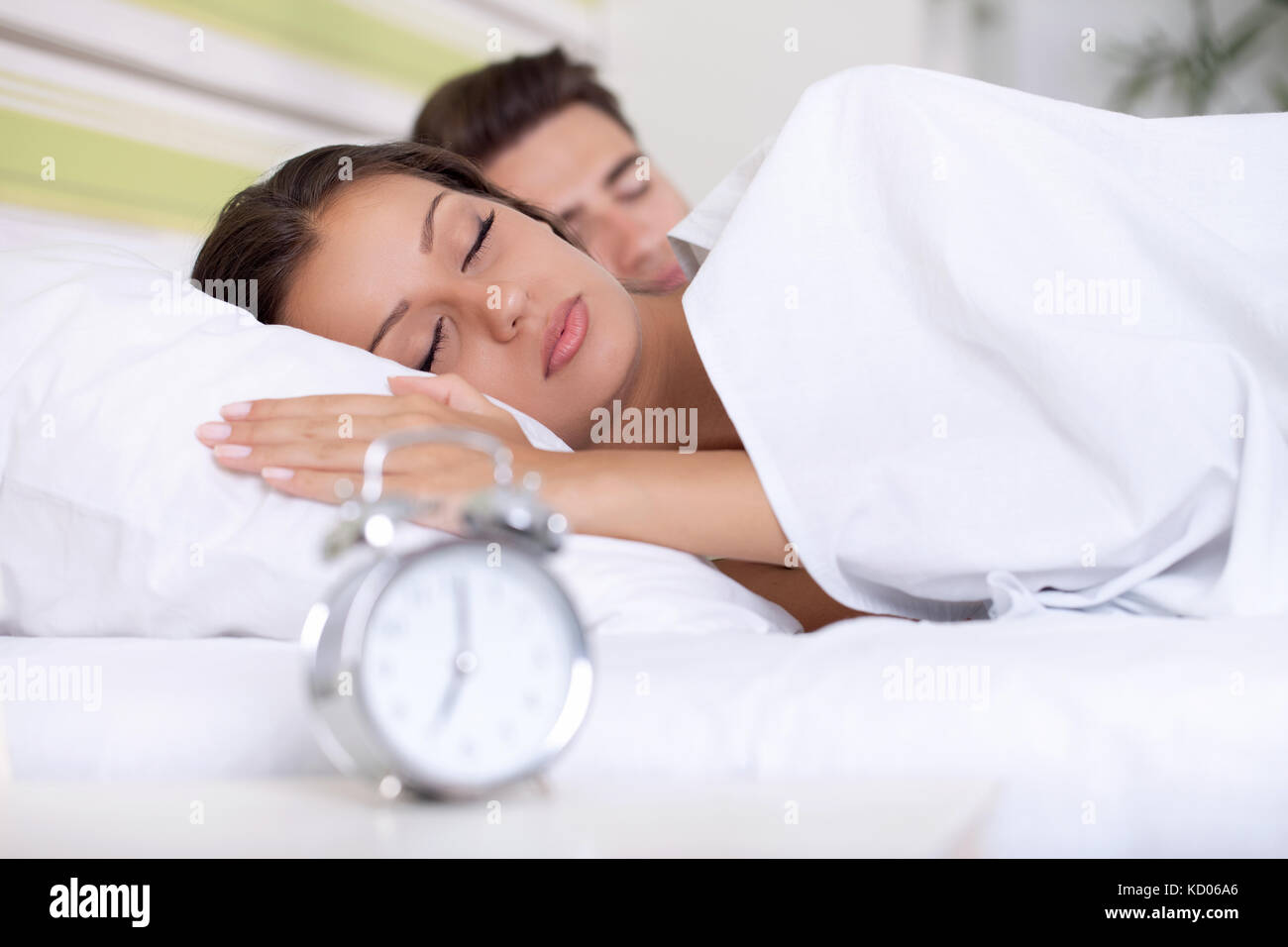 couple sleeping together in bed with alarm clock Stock Photo - Alamy