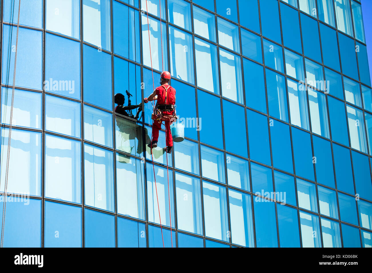 Washer wash the windows on high office building Stock Photo - Alamy