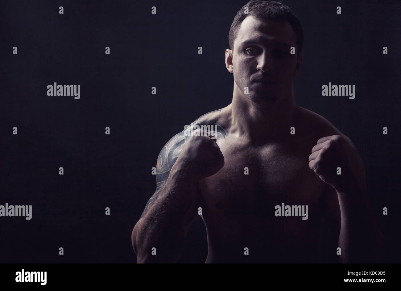Young boxer with clenched fists against a dark background. Boxing ...