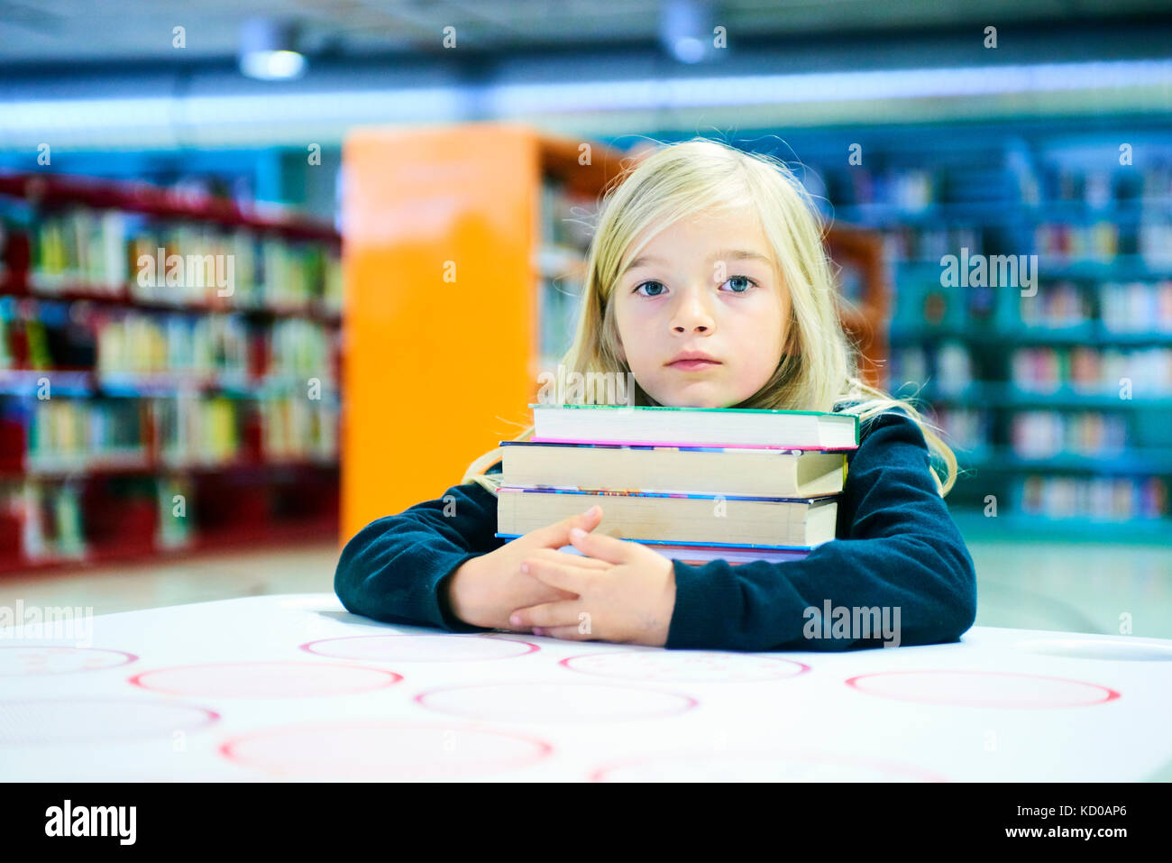 Child girl in public library with book Stock Photo - Alamy