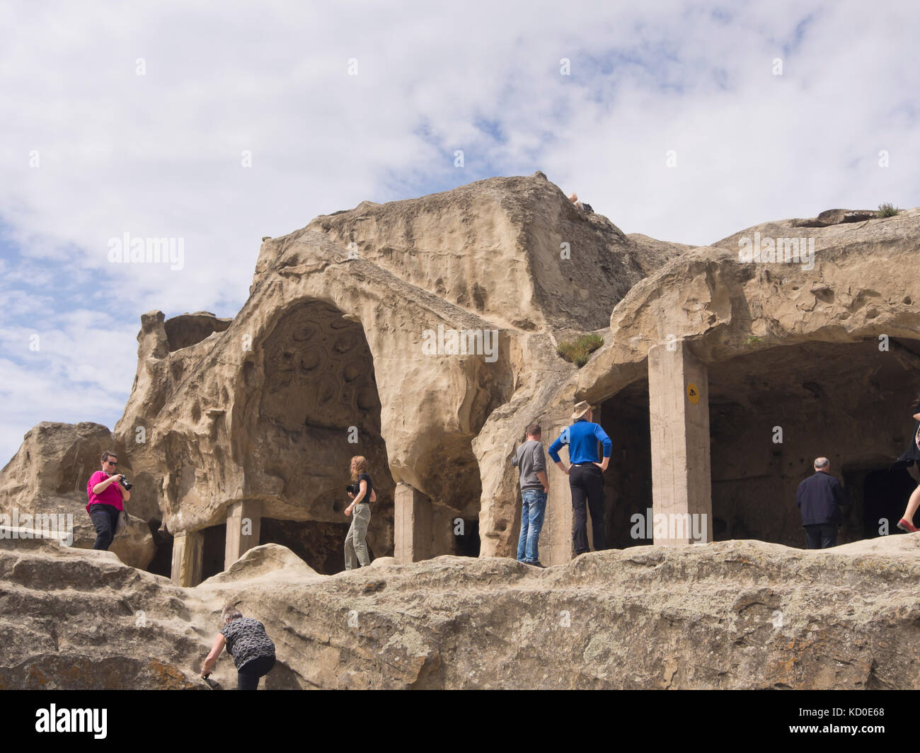 Tourists inspecting the Uplistsikhe cave complex archaeological site ...