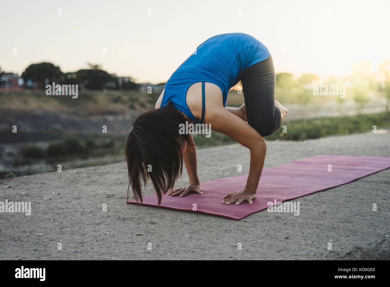 Mature woman outdoors, balancing on hands in yoga position Stock Photo ...