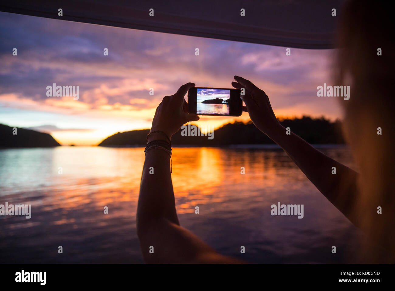 Woman photographing sunset with smartphone, Koh Rok Noi, Thailand, Asia ...