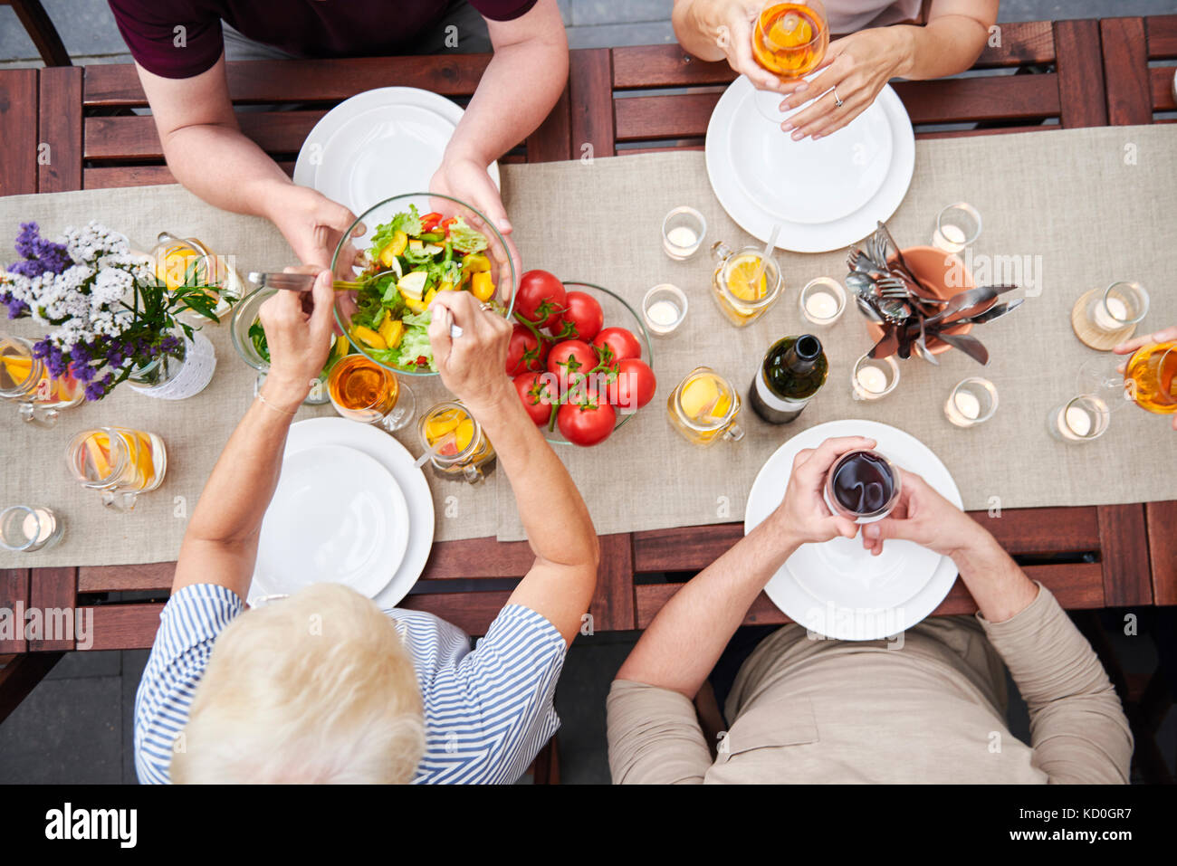 Overhead view of family handing salads at family lunch on patio Stock ...