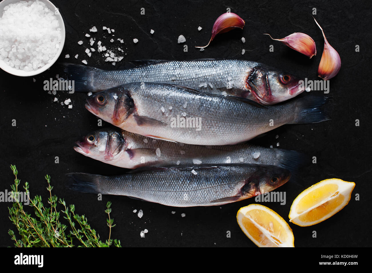 Raw fresh fish with ingredients on the black stone table Stock Photo ...