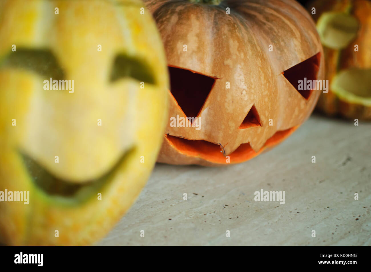 Three jack-o'-lanterns from pumpkin and melons on kitchen table ...