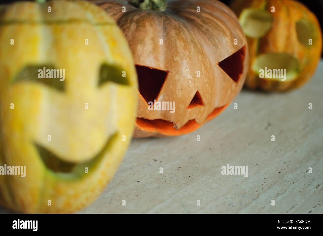 Three jack-o'-lanterns from pumpkin and melons on kitchen table ...