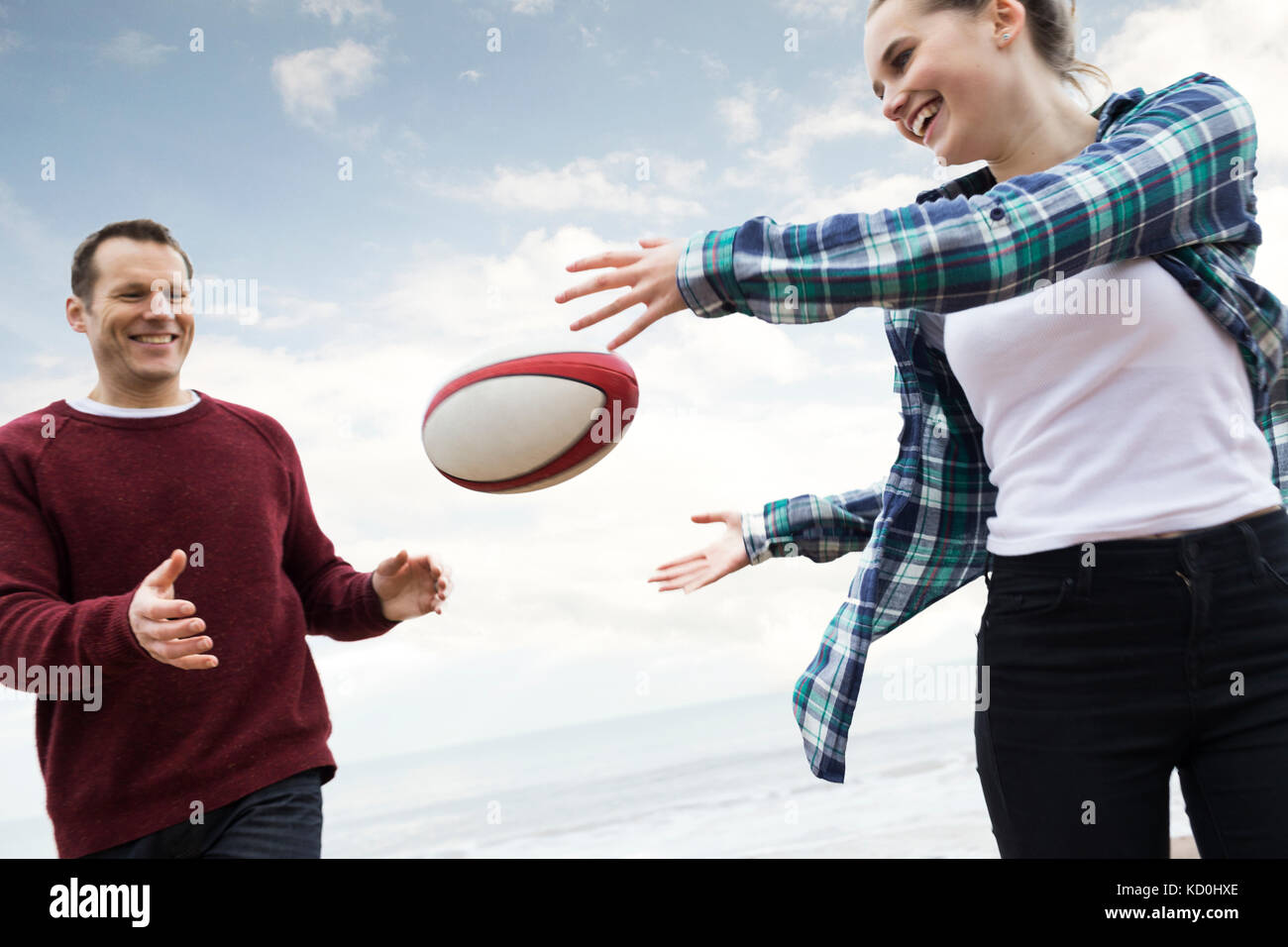 Father and daughter playing rugby on beach Stock Photo - Alamy