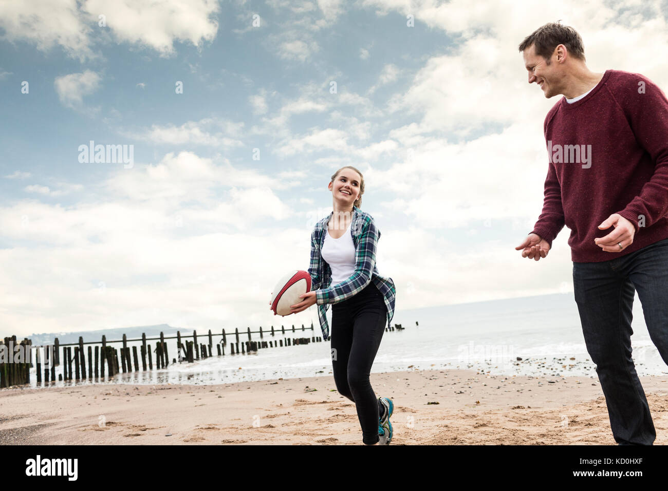 Father and daughter playing rugby on beach Stock Photo - Alamy