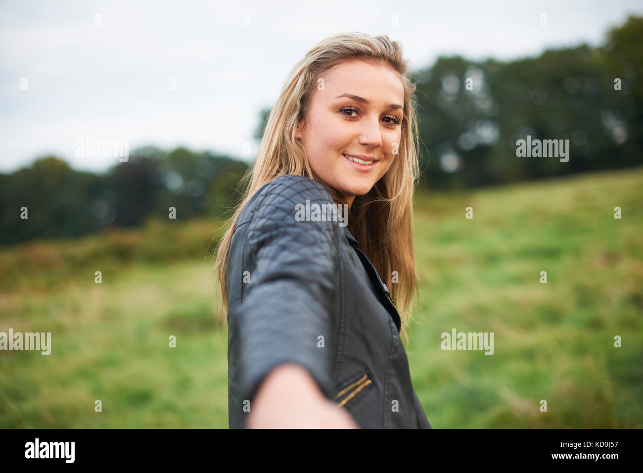 Personal perspective of young woman leading by hand in field Stock ...