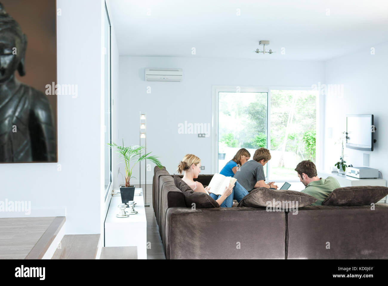 Parent couple with teenage son and daughter relaxing on sofa Stock ...