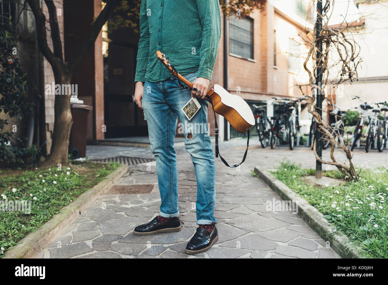 Neck down view on man standing path holding ukulele Stock Photo - Alamy
