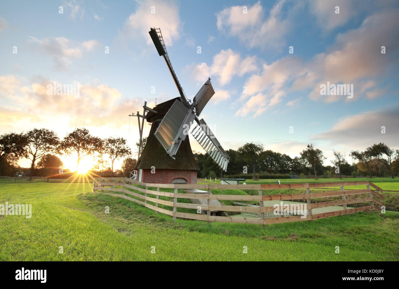 sunrise behind charming Dutch windmill on meadow Stock Photo - Alamy