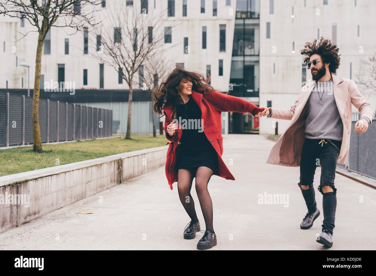 Young couple outdoors, running hand in hand Stock Photo - Alamy