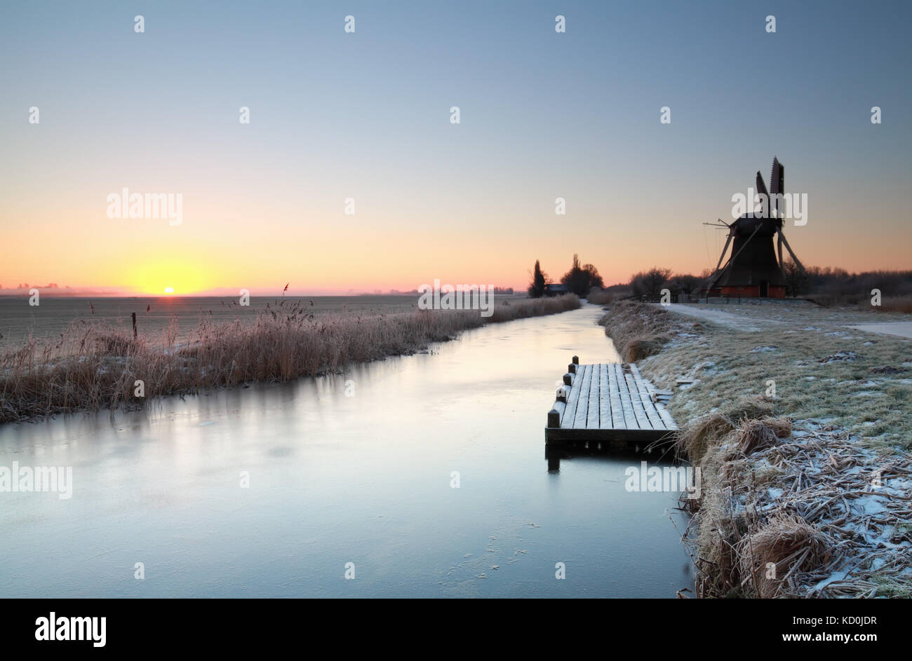 charming windmill by river at winter sunrise Stock Photo - Alamy