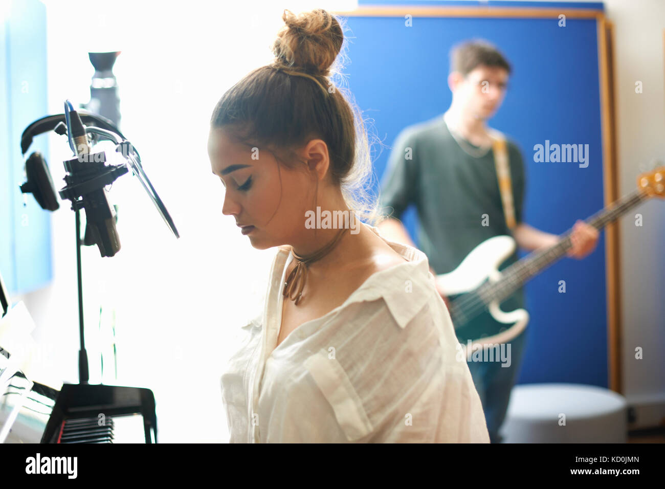 Young female college student preparing to sing in recording studio ...