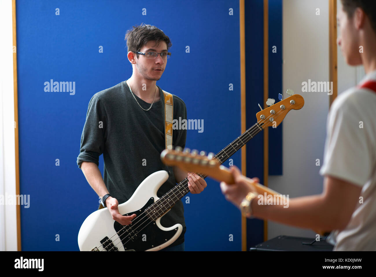 Young male college students playing guitars in recording studio Stock ...