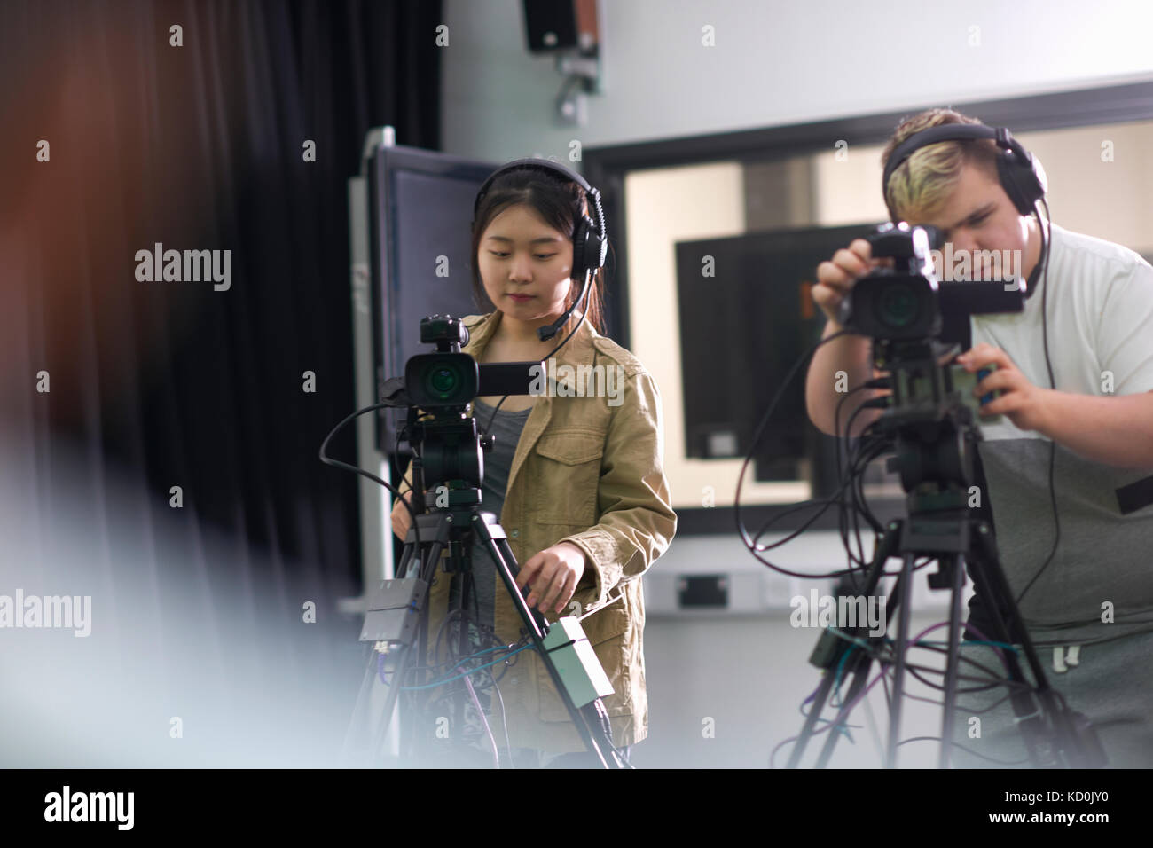 Over shoulder view of college students filming in TV studio Stock Photo ...