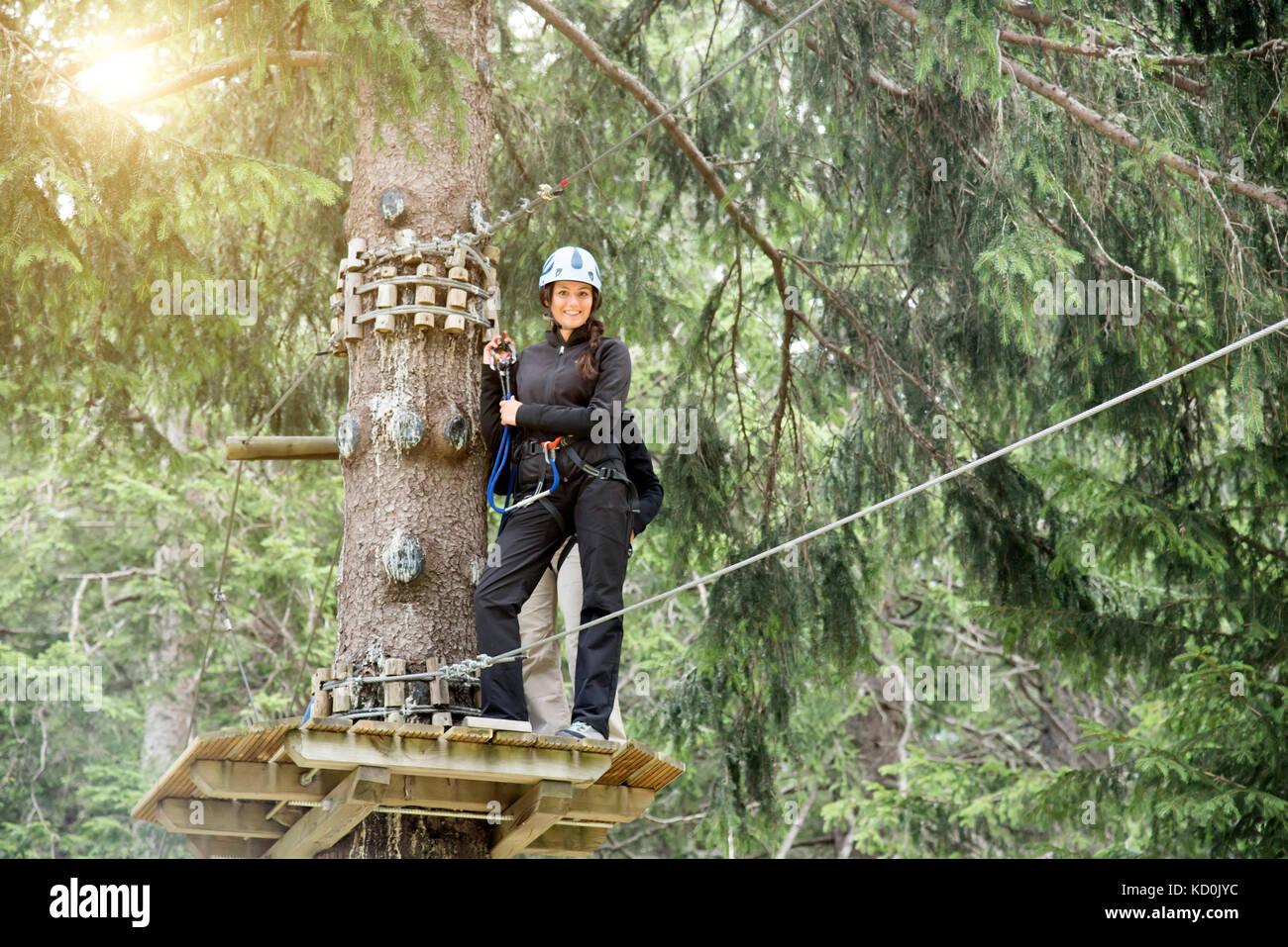 Teenage girl on high rope course looking at camera smiling Stock Photo ...