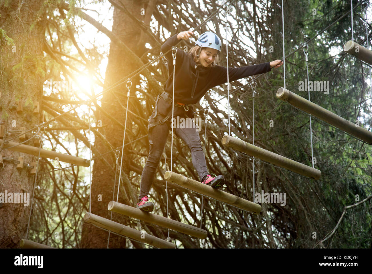 Teenage girl on high rope course Stock Photo - Alamy