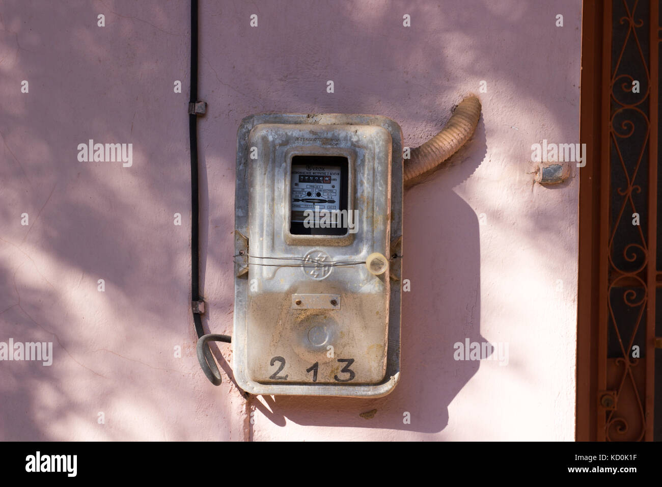 an electricity panel switch outside of a pink house with cables and ...