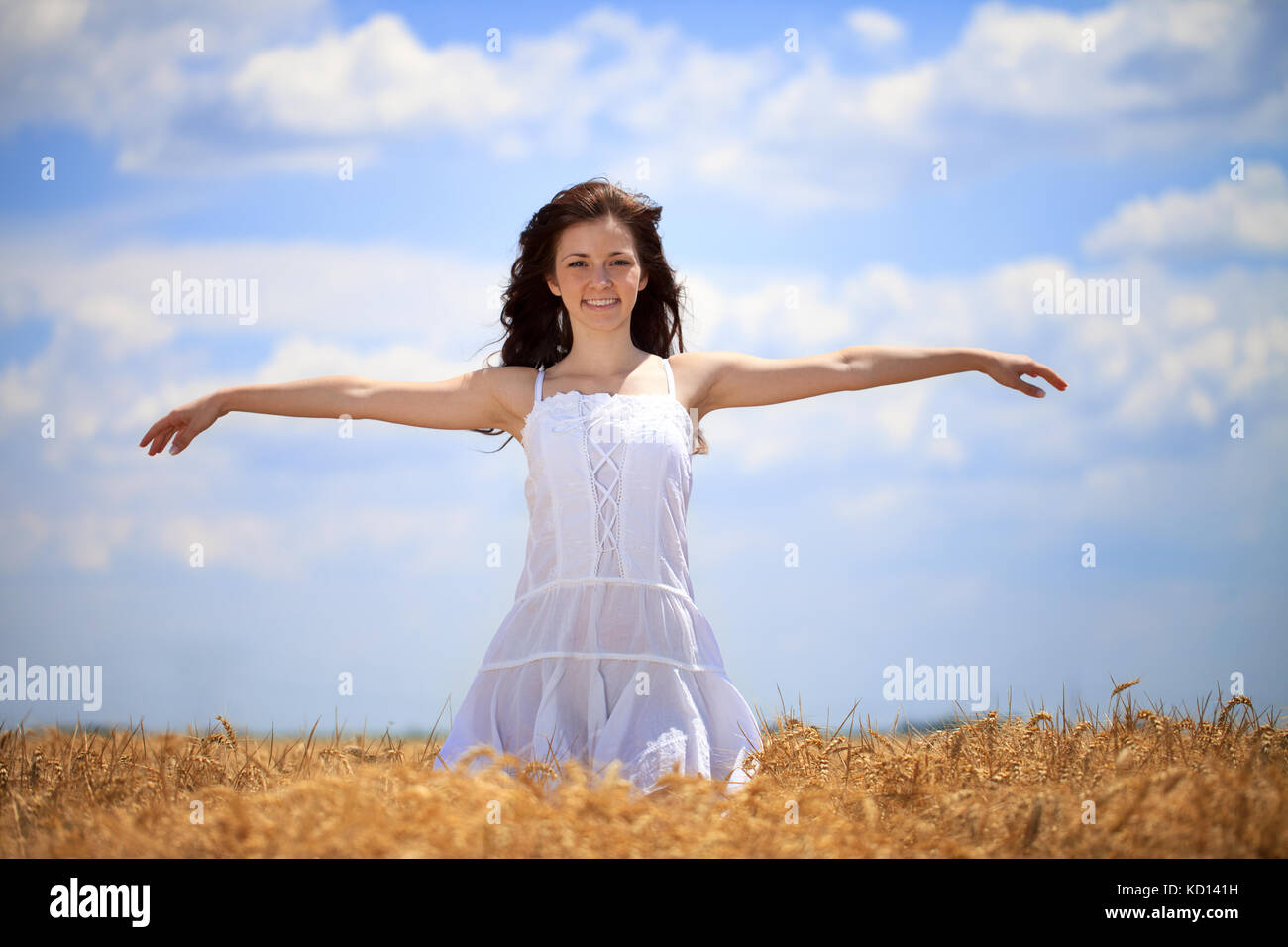 Woman with arms stretched out in wheat field Stock Photo - Alamy
