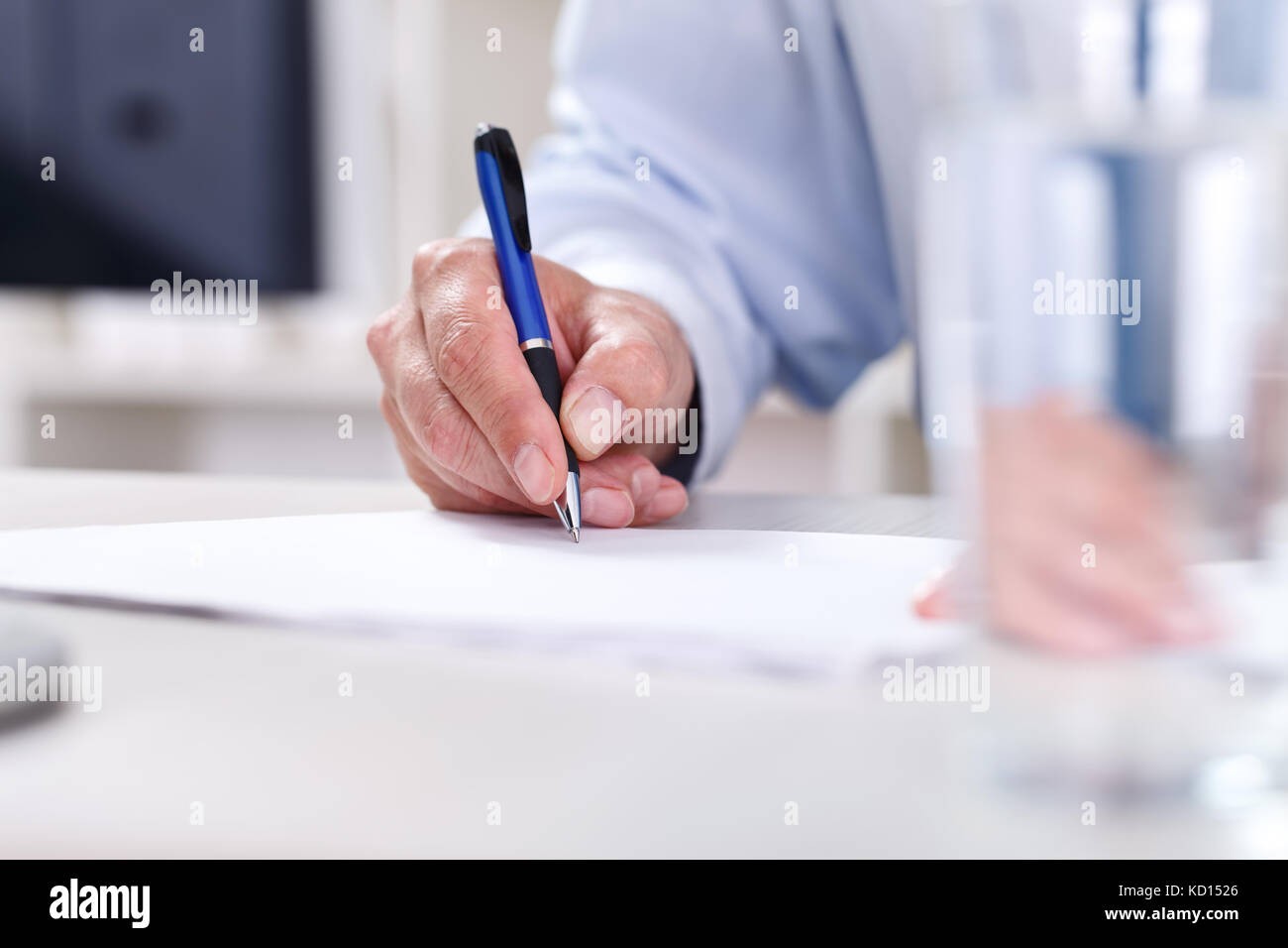 Male hand writing on a paper, signing a contract Stock Photo - Alamy