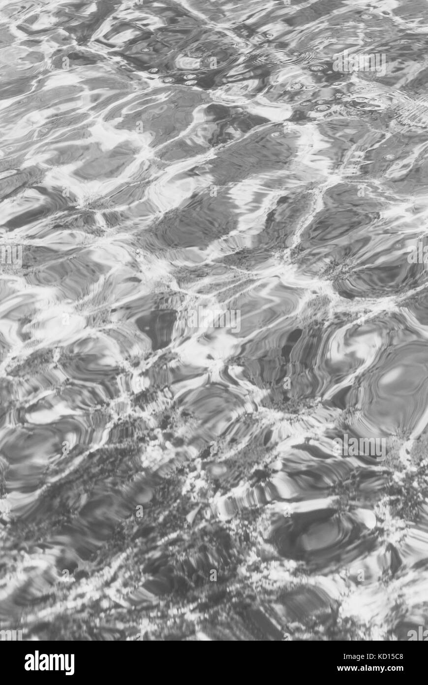 Refraction of light in clear water with small waves. Black and white ...
