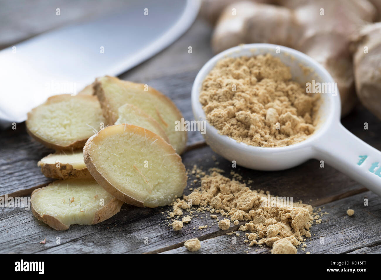 Ginger root, slices, and powder with knife in background Stock Photo ...