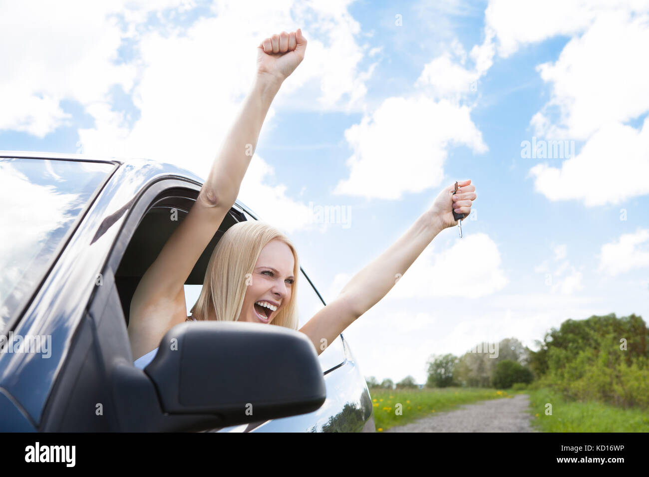 Happy Young Woman Raising Hand Out Of Car Window Stock Photo - Alamy