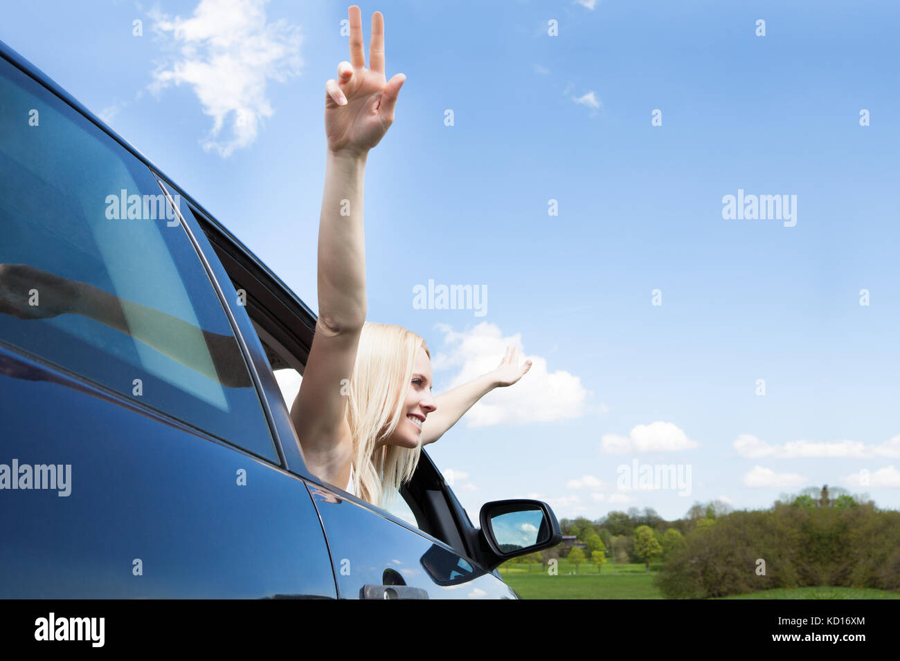 Happy Young Woman Raising Hand Out Of Car Window Stock Photo - Alamy