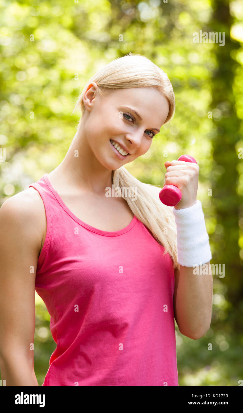 Young Woman Using Dumbbells For Workout In Park Stock Photo - Alamy