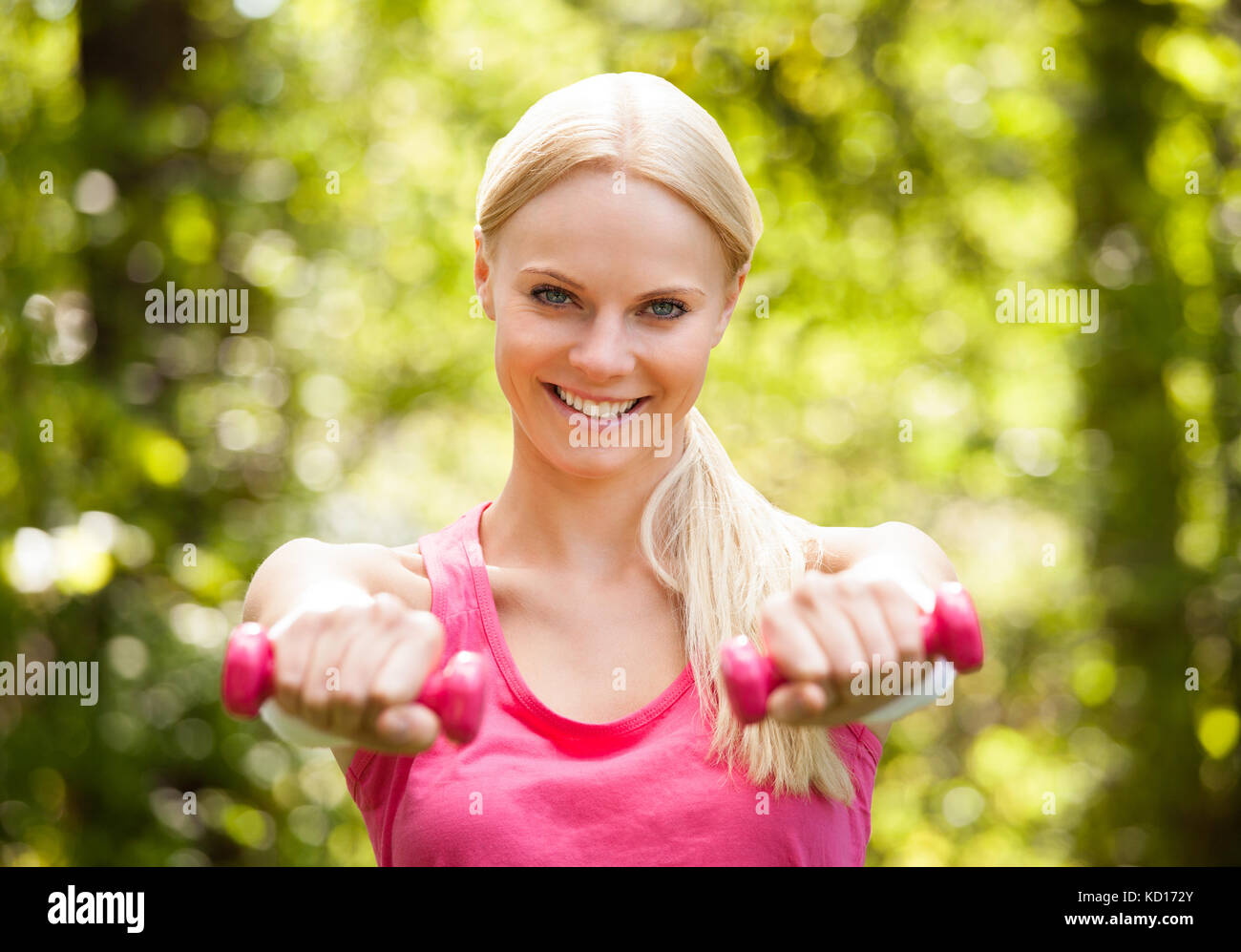 Young Woman Using Dumbbells For Workout In Park Stock Photo - Alamy