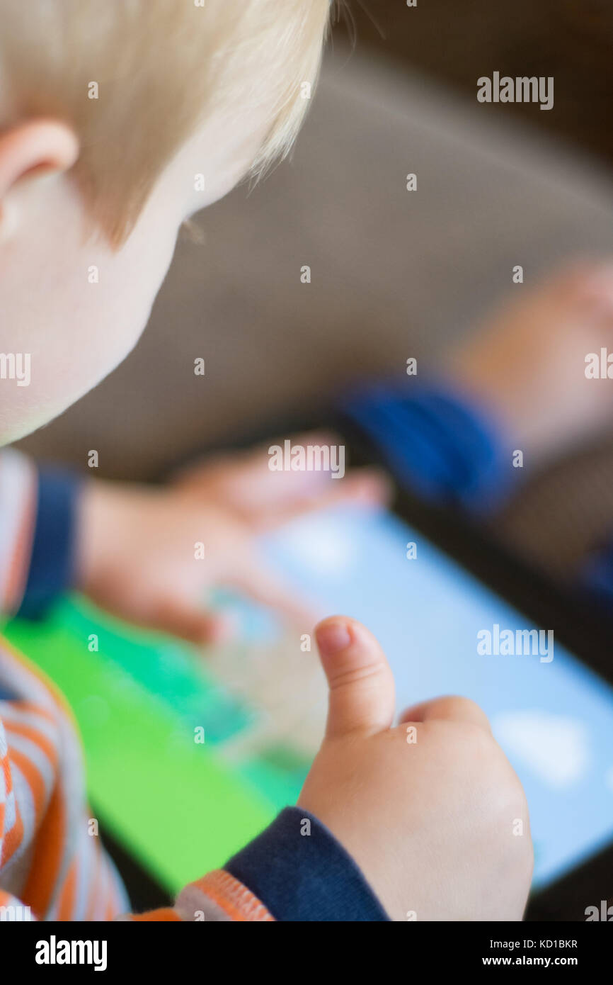 Child using a touch screen tablet to play learning game Stock Photo - Alamy
