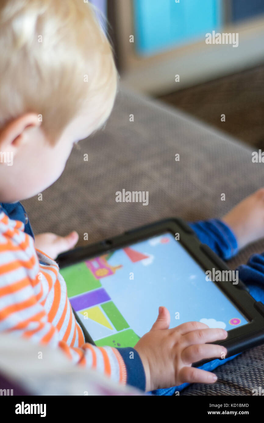 Child using a touch screen tablet to play learning game Stock Photo - Alamy