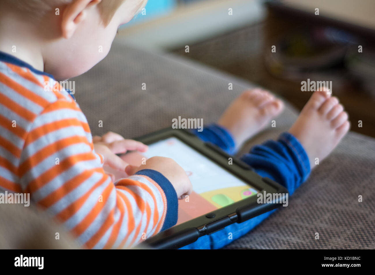 Child using a touch screen tablet to play learning game Stock Photo - Alamy