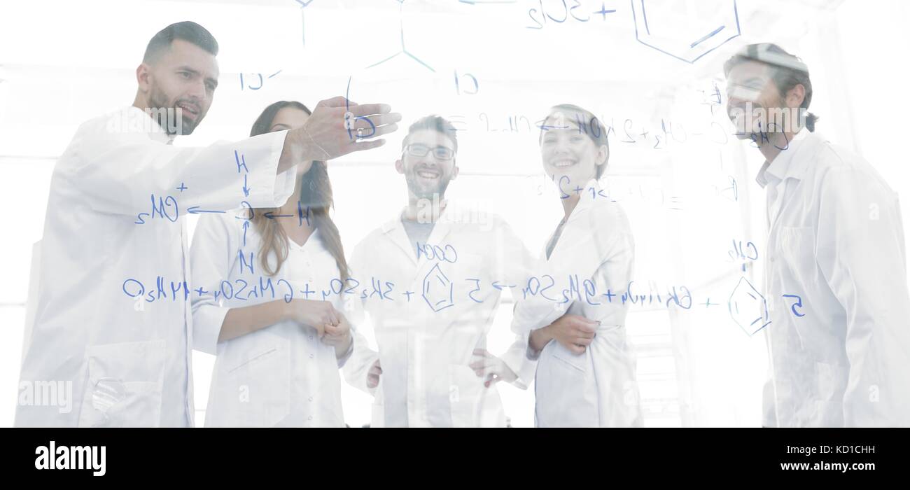 group of laboratory scientists discussing their research in the ...