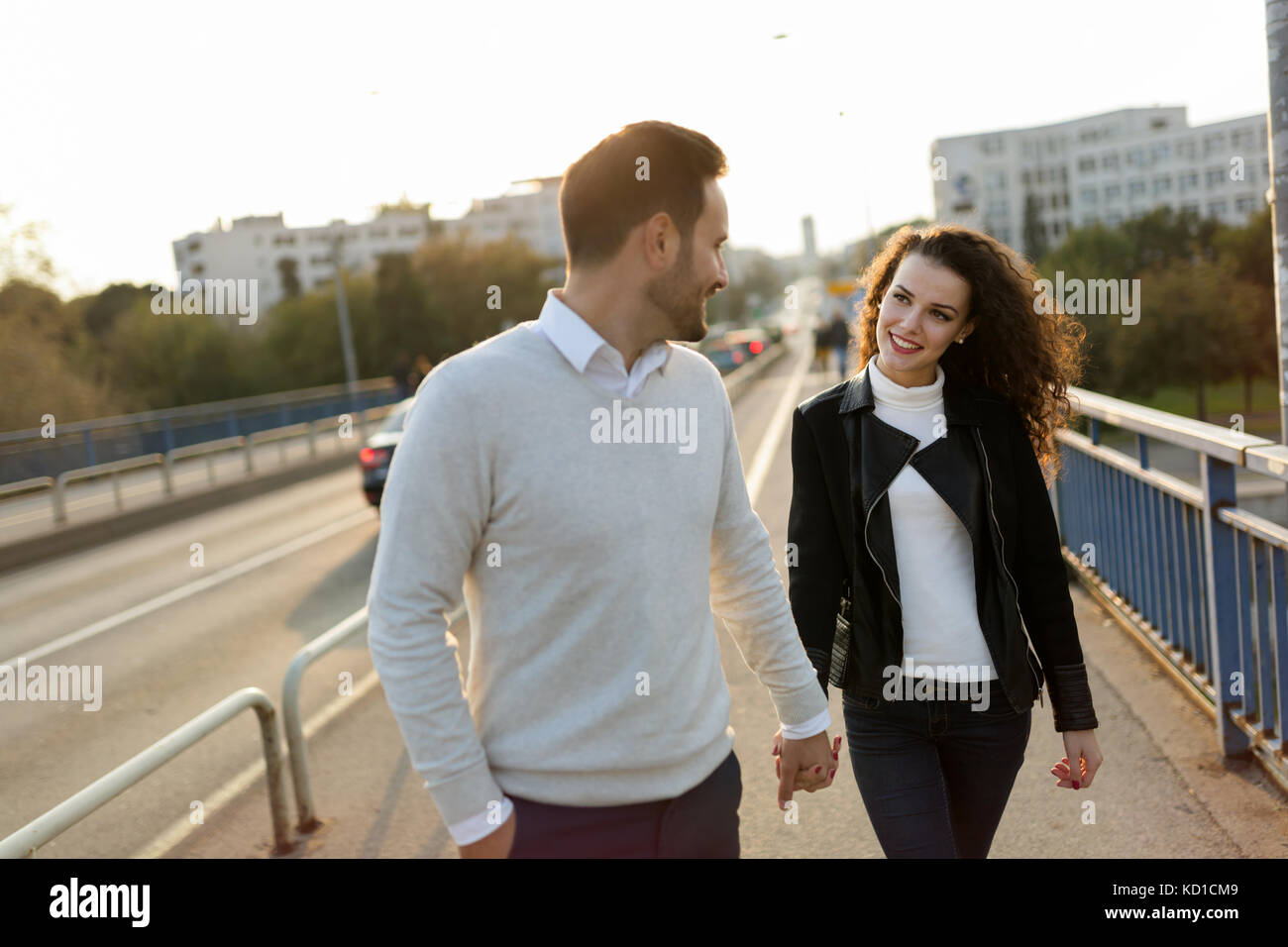Happy young couple walking hand in hand Stock Photo - Alamy