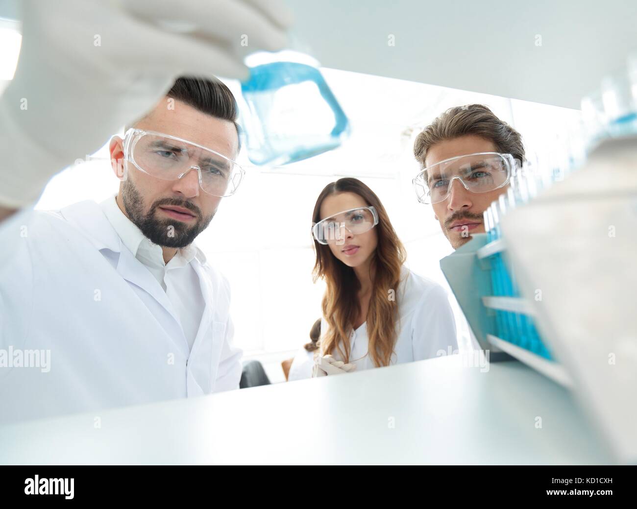closeup. scientist and assistant studying the solution in the glass ...
