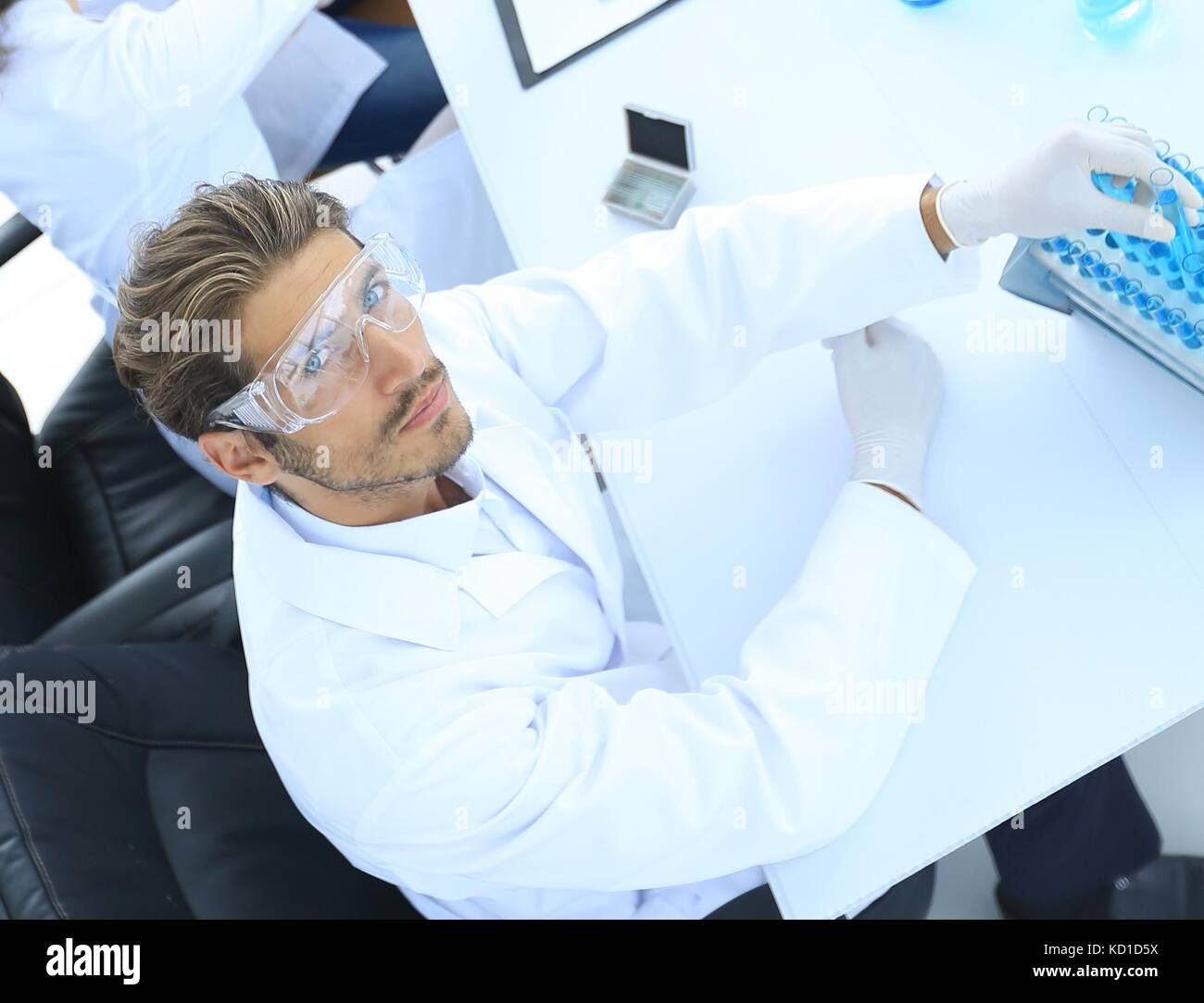 Scientists working with a microscope and make notes in the workplace ...