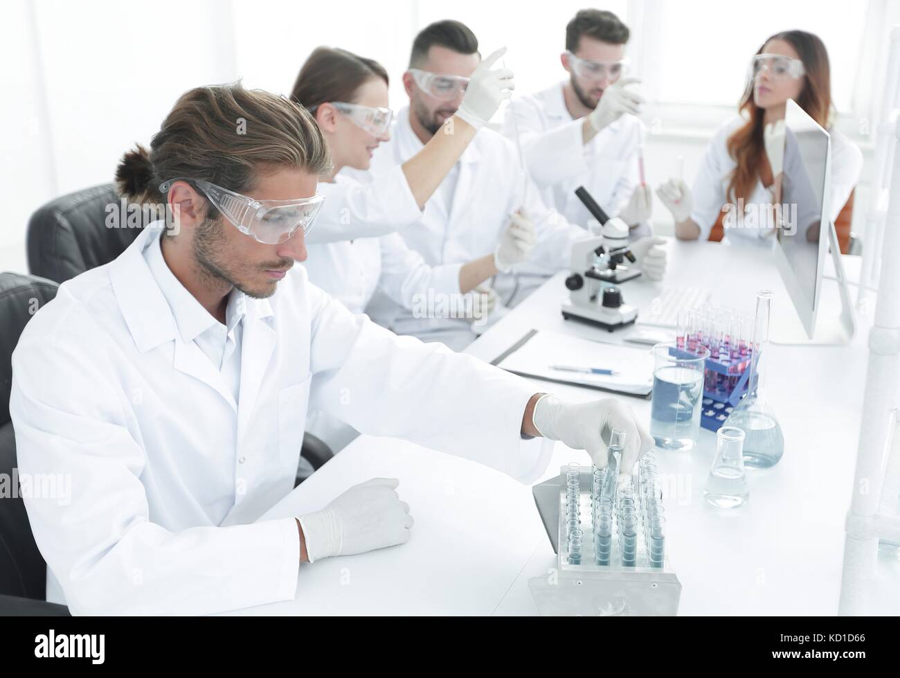 Scientists working with a microscope and make notes in the workplace ...