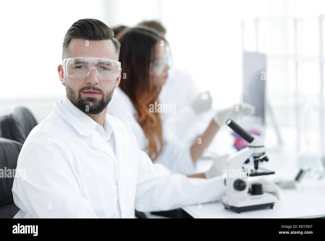microbiologist and his colleagues are sitting in a modern laboratory ...