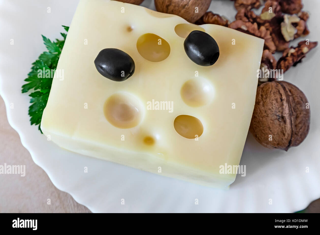 Cheese and walnuts on a plate on the table Stock Photo - Alamy