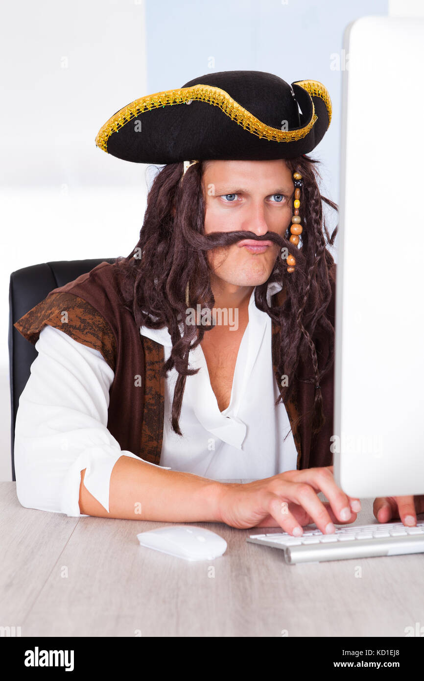 Portrait Of A Young Pirate Using Computer At Desk Stock Photo - Alamy