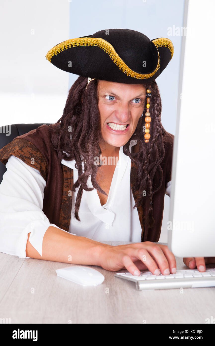 Portrait Of A Angry Pirate Clenching His Teeth Using Computer Stock ...