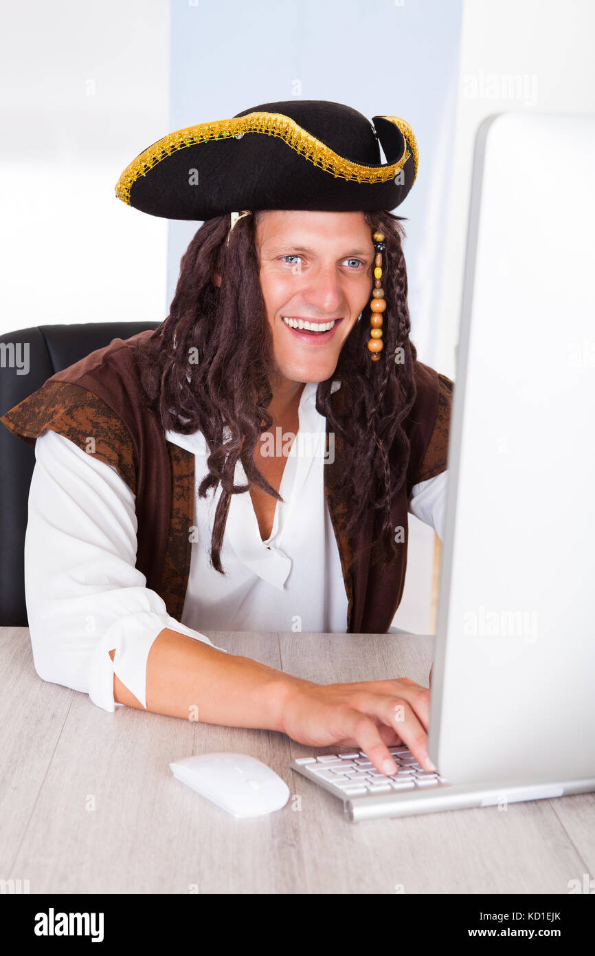 Portrait Of A Happy Young Pirate Using Computer Stock Photo - Alamy