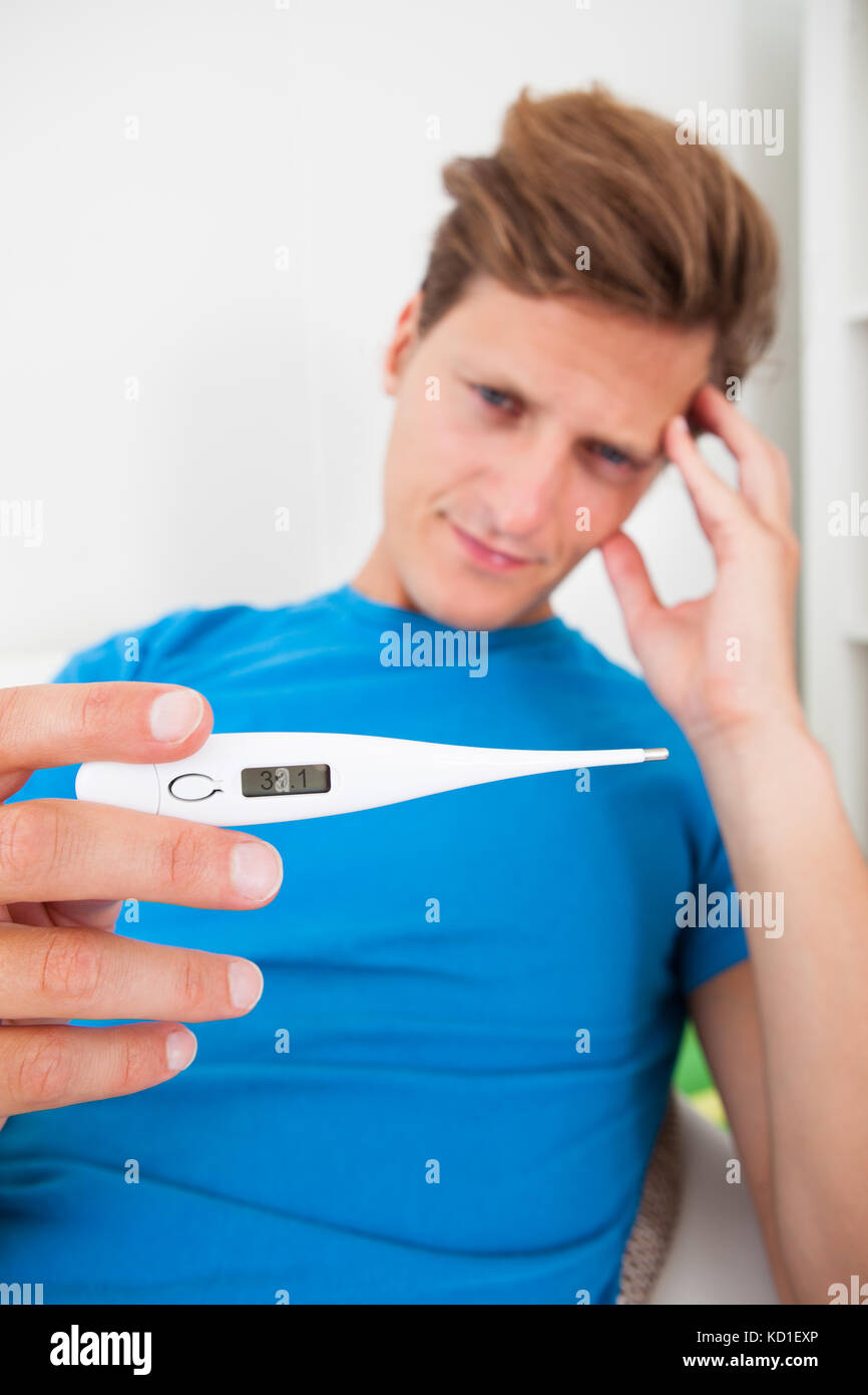 Man Suffering From Fever And Measuring Temperature With Thermometer ...