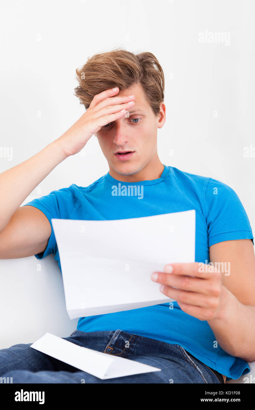 Tensed Young Man With Hand On Forehead Looking At Paper Stock Photo - Alamy