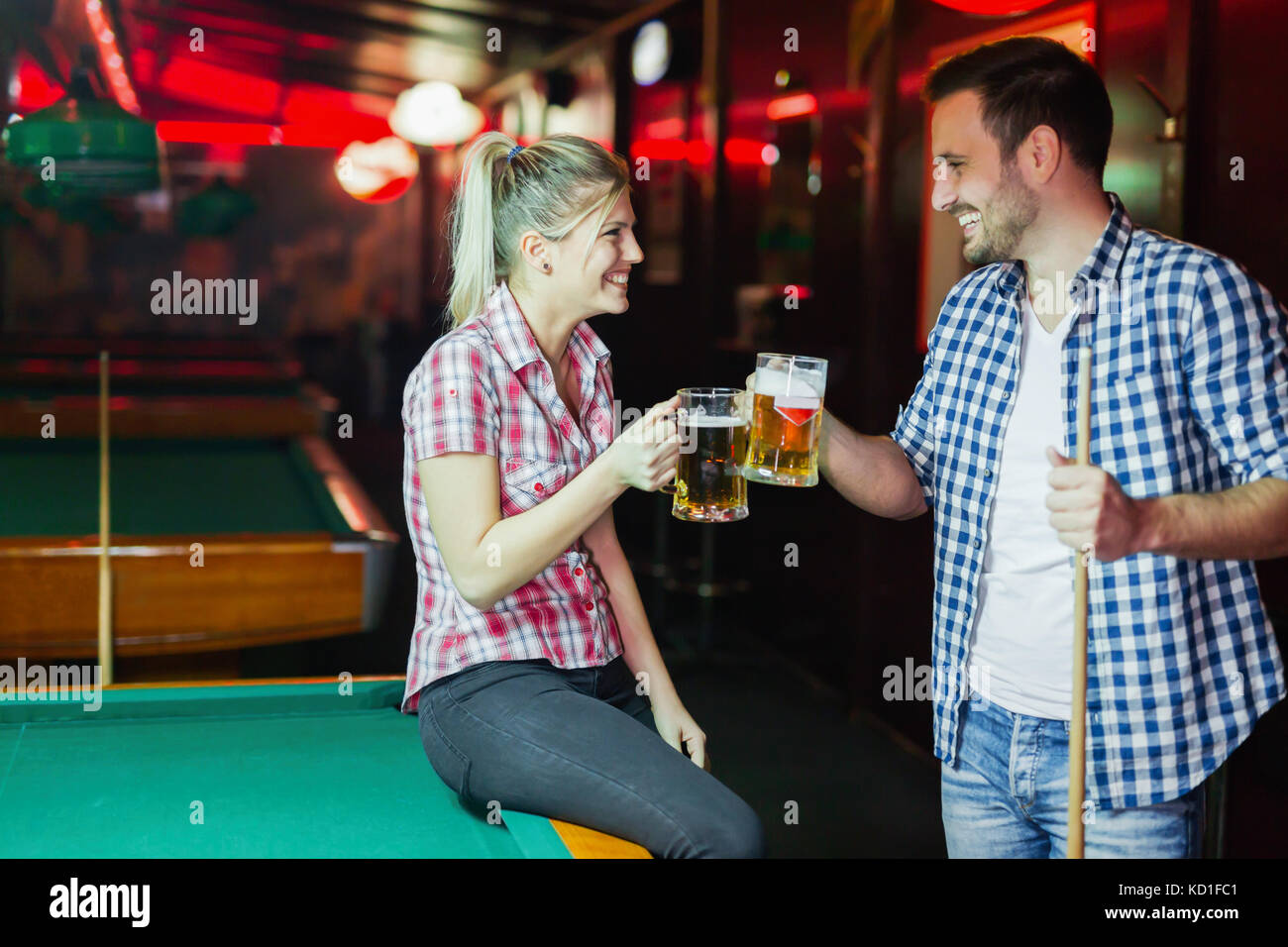 Happy couple drinking beer and playing snooker Stock Photo - Alamy
